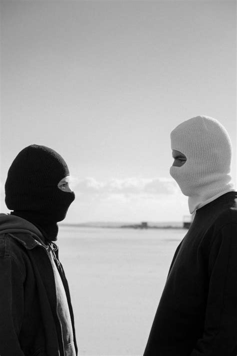 Woman In A Balaclava Leaning On A Wall Covered With Photos · Free Stock