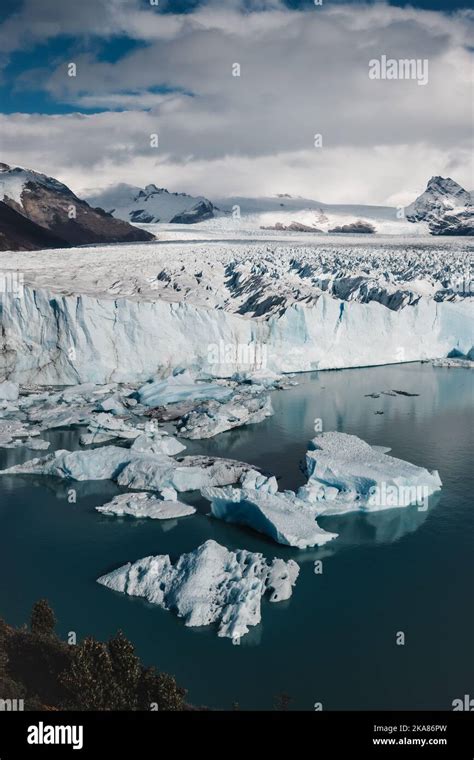 A Vertical Shot Of Icebergs And Glaciers In The Water Near Snowy