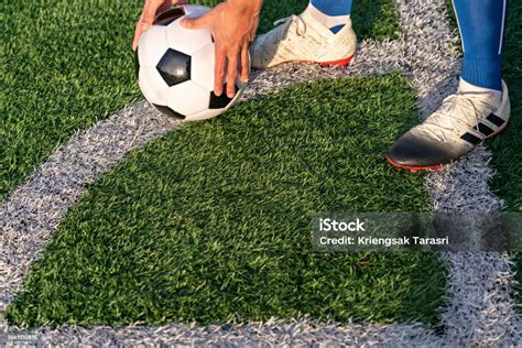 일출 동안 축구장에서 공을 들고 서 있는 선수 하늘 배경에 그물에 있는 축구공 공 움직임 축구 클럽에서 인기 있는 스포츠 월드컵