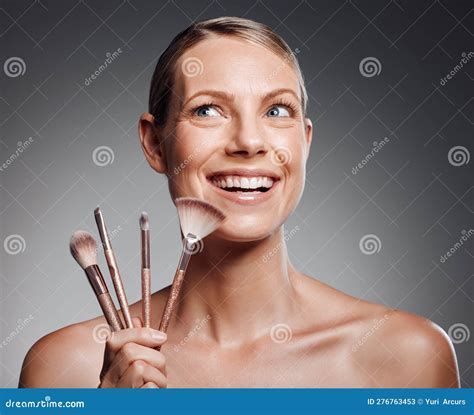 Beautiful Mature Woman Posing With Makeup Brush In Studio Against A