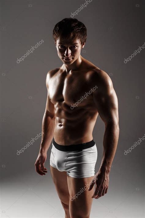 Hombre atlético fuerte mostrando cuerpo muscular y abdominales de seis