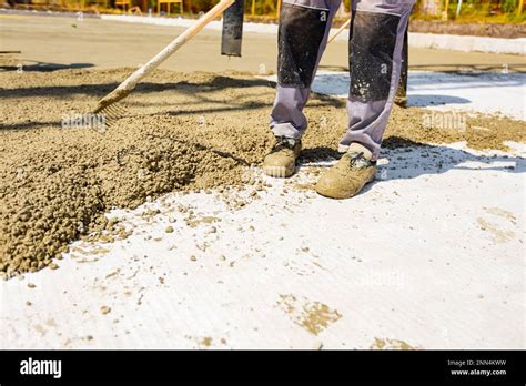 Construction Worker Rigger Is Using Rake To Spreading Leveling