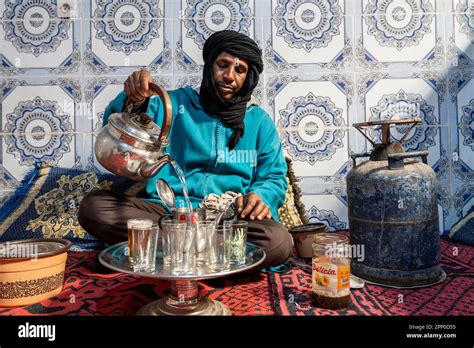 Berber Man Dressed In Djellaba And Black Turban Serving Tea In The
