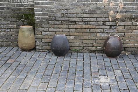 검은 색과 갈색 도자기 냄비 인 세 개의 고대 중국 와인 항아리가 회색 벽돌로 된 중국의 오래된 거리 바닥에 앉아 있습니다 갈색에 대한 스톡 사진 및 기타 이미지 Istock