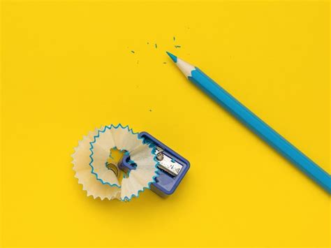 Premium Photo Sharpened Blue Pencil And Pencil Sharpener On A Yellow