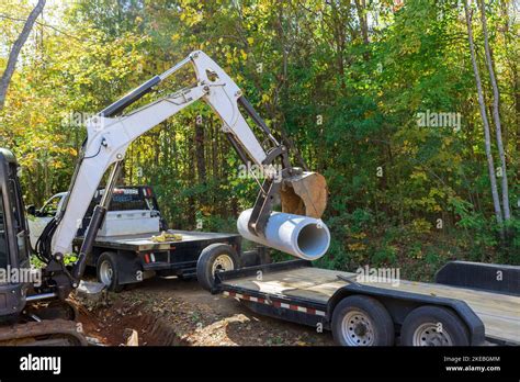 Les Travailleurs Utilisent Le Tracteur Pour Soulever Les Tuyaux Dégout