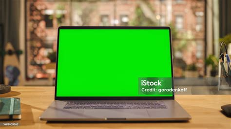 거실의 나무 책상 위에 서 있는 녹색 화면 모형이 있는 노트북 컴퓨터 디스플레이 가정이나 크리에이티브 로프트 사무실의 크로마 키 모니터 0명에 대한 스톡 사진 및 기타