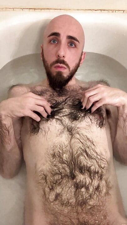 Худенькая лысая белая выдра с ярко голубыми глазами и черными окрашенными ногтями показывает