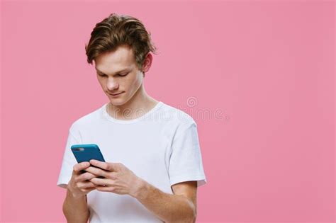 Cute Nice Guy With A Thoughtful Smile Typing A Text Message On The