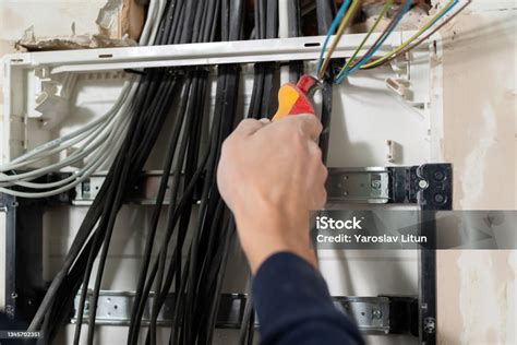 전기와 위험한 작업 전기 기술자는 전기 패널을 설치하고 전선을 준비합니다 전기 기술자가 전기 상자 근처에 서 있습니다 가정 생활에 대한 스톡 사진 및 기타 이미지 Istock