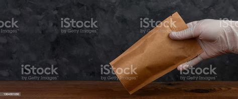 파우치 가방 모형 보호 장갑을 끼고 커피 콩 나무 배경을 가진 갈색 크래프트 페이퍼 팩이 있습니다 짐 싸기에 대한 스톡 사진 및