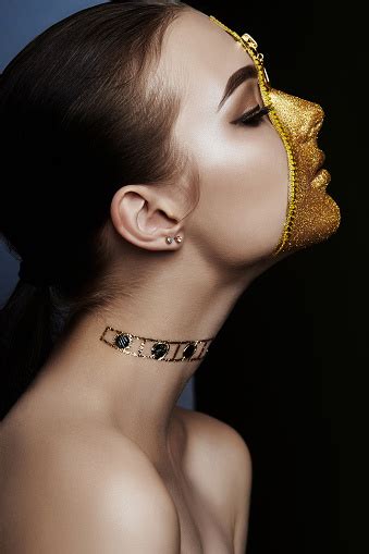 피부에 여자 골든 컬러 지퍼 의류의 크리에이 티브 어두운 메이크업 얼굴 패션 뷰티 크리에이 티브 화장품과 스킨 케어 할로윈 어두운 배경 아름 다운 큰 눈 및 부드러운 피부에