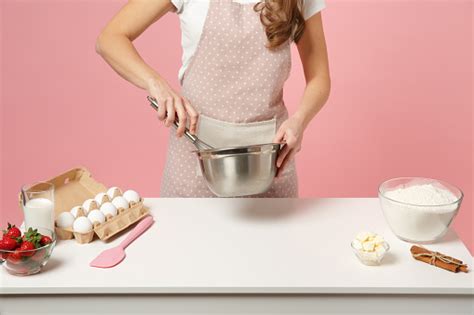 자른 여성 요리사 요리사 또는 앞치마 흰색 T 셔츠 모자 요리사 모자 요리 케이크 또는 테이블에 분홍색 파스텔 배경에 고립 된 식탁에서 컵 케 잌은 스튜디오 복사 공간 음식