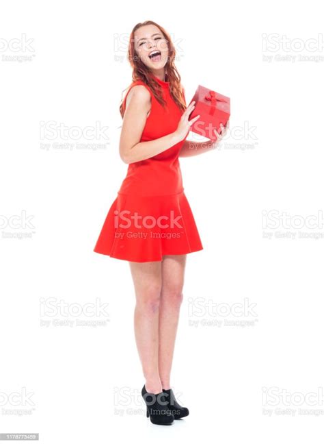 1 인용 1819 세의 전체 길이 아름 다운 빨간 머리 백인 젊은 여자 앞 흰색 배경 착용 드레스와 하이힐 을 입고 미소 행복 쾌활 하 고 선물 상자 상자를 들고컨테이너
