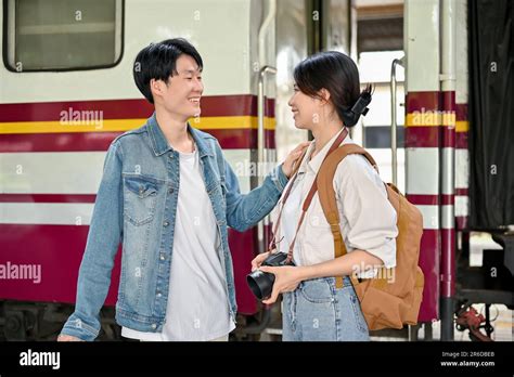 A Lovely Young Asian Tourist Couple Enjoys Talking On The Platform
