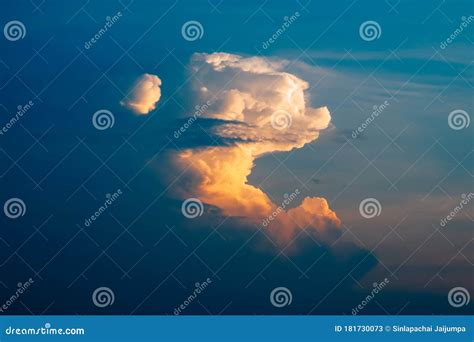 Large White Cumulus Clouds With Orange Sunset At Dusk And Blue Sky