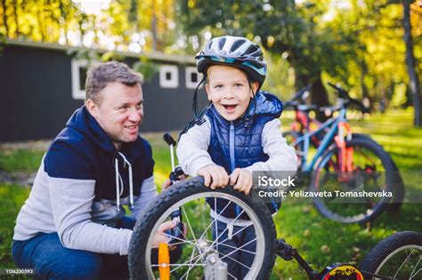 아버지의 날 코 카시 안 아빠와 5 살짜리 아들은 자전거를 수리 잔디밭에 푸른 잔디에 집 근처 뒤뜰에 자전거 바퀴를 펌핑 아빠가