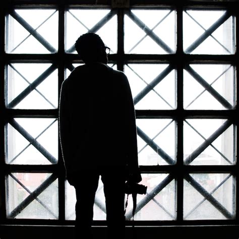 Vista trasera de un hombre silueta con una cámara de pie junto a la