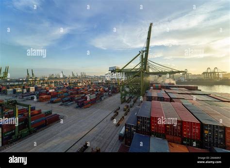 Sunrise Over A Bustling Container Port Showcasing Rows Of Colorful