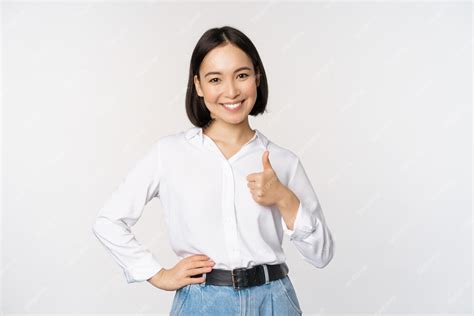 흰색 배경 위에 Smth 좋은 평판처럼 추천하는 승인에서 엄지손가락을 보여주는 자신감 있는 아시아 여성의 이미지 무료 사진