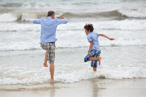 Pai E Filhos Na Praia Que Joga Na Areia Imagem De Stock Imagem De