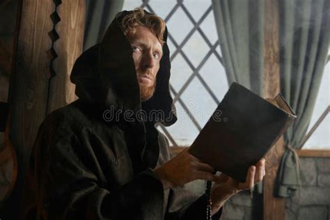 Old Medieval Monk Reading Sacred Religious Book Praying With Rosary Beads In Hand Stock Image