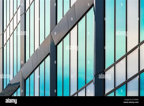 Modern Glass Facade With Reflective Panels And Angular Architectural Details In Urban Design