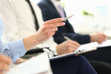 Number Of Business Delegates Listen To Lecture And Take Notes Sitting In Front Of Speaker At