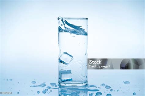 얼음 조각이 물 잔에 떨어졌습니다 맑은 유리에서 물이 튀었다 신선한 개념 가득 찬에 대한 스톡 사진 및 기타 이미지 가득 찬