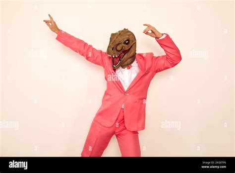 Crazy Young Guy Wearing Pink Suit And Funny Dinosaur Mask Dancing And