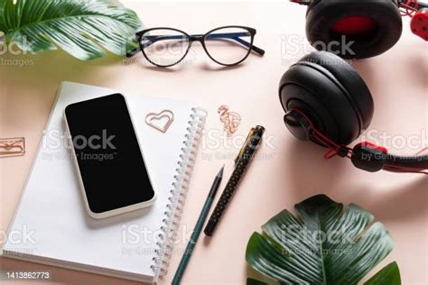 스마트 폰 빈 메모장 헤드폰 괴물 꽃 잎 안경 펜 종이 클립 밝은 배경에 연필 상단보기 텍스트를위한 공간을 확보하십시오