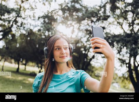 Smiling Teenage Girl Wearing A Turquoise T Shirt And Headphones Taking