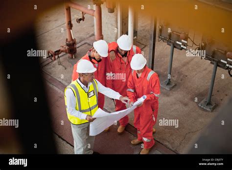 Workers With Blueprints At Oil Refinery Stock Photo Alamy