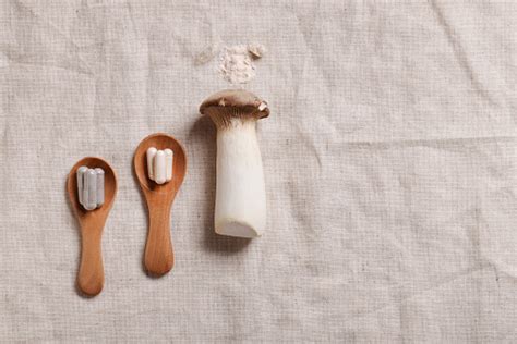 버섯과 천연 허브 알약은 섬유 배경에 나무 숟가락에 있습니다 환경 친화적이고 건강하며 의료 보충제 개념 복사 공간 0명에 대한