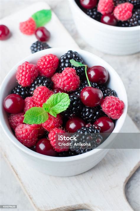 회색 콘크리트 테이블 배경에 흰색 그릇에 여름 신선한 딸기 닫습니다 채식 음식블랙베리 라스베리 체리 건강한 생활방식에 대한 스톡