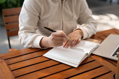 Premium Photo A Woman Writing In Her Notebook Listing Ideas In A Book