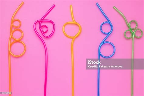 분홍색 종이 카드에 플라스틱 나선형 멀티 컬러 튜브 곡선 칵테일 빨대의 추상적 인 다채로운 배경 간결한 디자인 재미 분위기의 개념 현대적인 스타일 감정에 대한 스톡 사진 및
