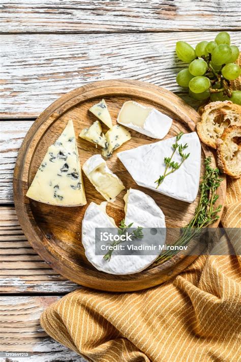 둥근 나무 도마에 다양한 치즈 카망베르 브리 블루 치즈와 포도 흰색 나무 배경 위쪽 보기 0명에 대한 스톡 사진 및 기타 이미지 Istock