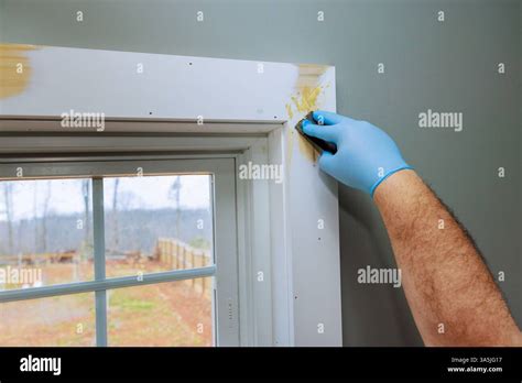 Homeowner Is Carefully Patching Holes In Window Trim With Renovating Their Living Space Stock