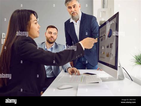Young Business Woman Showing Her Colleagues Stats Financial Data On Pc