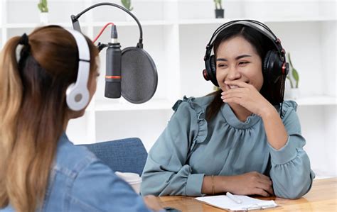 두 명의 아시아 젊은 여성 헤드폰으로 남자 라디오 호스트 마이크를 말하면서 대화 스튜디오에서 함께 방송에서 팟 캐스트를