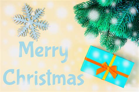 비문 메리 크리스마스입니다 오렌지 리본으로 파란색 상자에 선물 어떤 거짓말 아래 나무 근처 눈 효과 함께 사진입니다 축제 엽서입니다 12월에 대한 스톡 사진 및 기타 이미지