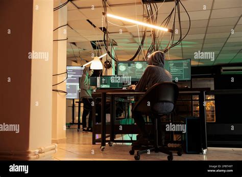 Young Hacker Cracking Firewall Encryption On Multi Monitors Writing