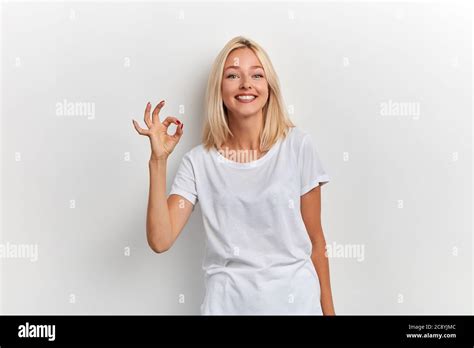 Portrait Of A Pretty Positive Smiling Woman Showing Okay Sign And Over
