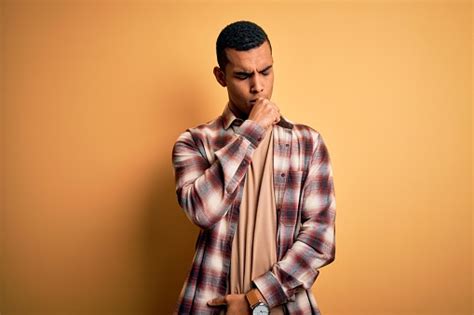 젊은 잘 생긴 아프리카 계 미국인 남자 캐주얼 셔츠를 입고 노란색 배경 위에 서 서 기분이 좋지 않고 감기 또는 기관지염에 대