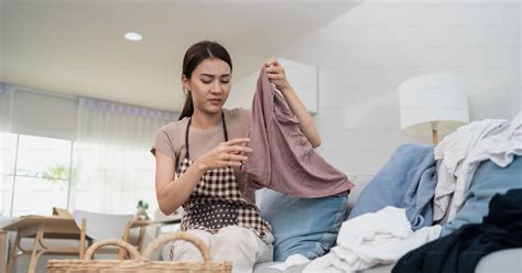 집에서 거실에서 청소하는 아시아 청소 서비스 여성 노동자 아름다운 소녀 가정부 청소부는 집안의 가사 집안일을 위해 지저분한 더러운 천을 바구니에 넣는 것에 좌절감을