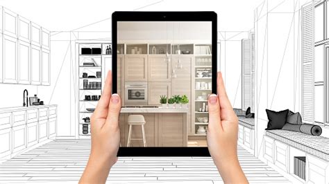 손은 현대 흰색과 나무 부엌을 보여주는 태블릿을 들고 청사진 Cad 스케치 배경 증강 현실 개념 가구 및 인테리어 디자인 제품을 시뮬레이션 하는 응용 프로그램 가구에 대한