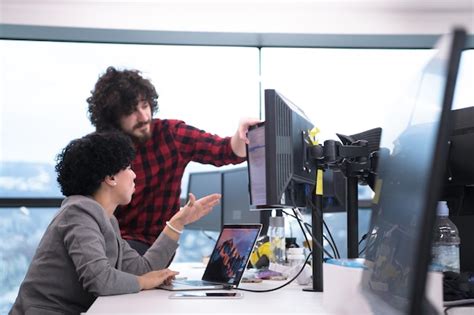 Premium Photo Young Software Developers Couple Using Laptop And Desktop Computer While Writing