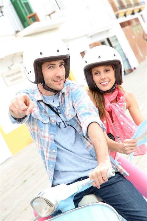 Tourists In Ibiza With Scooter Looking At City Map Colourbox