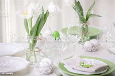 흰색 튤립과 녹색과 흰색 색상의 요리와 부활절 테이블의 장식 및 테이블 설정 부활절 토끼의 형태로 부활절 장식 흰색 폴카 도트
